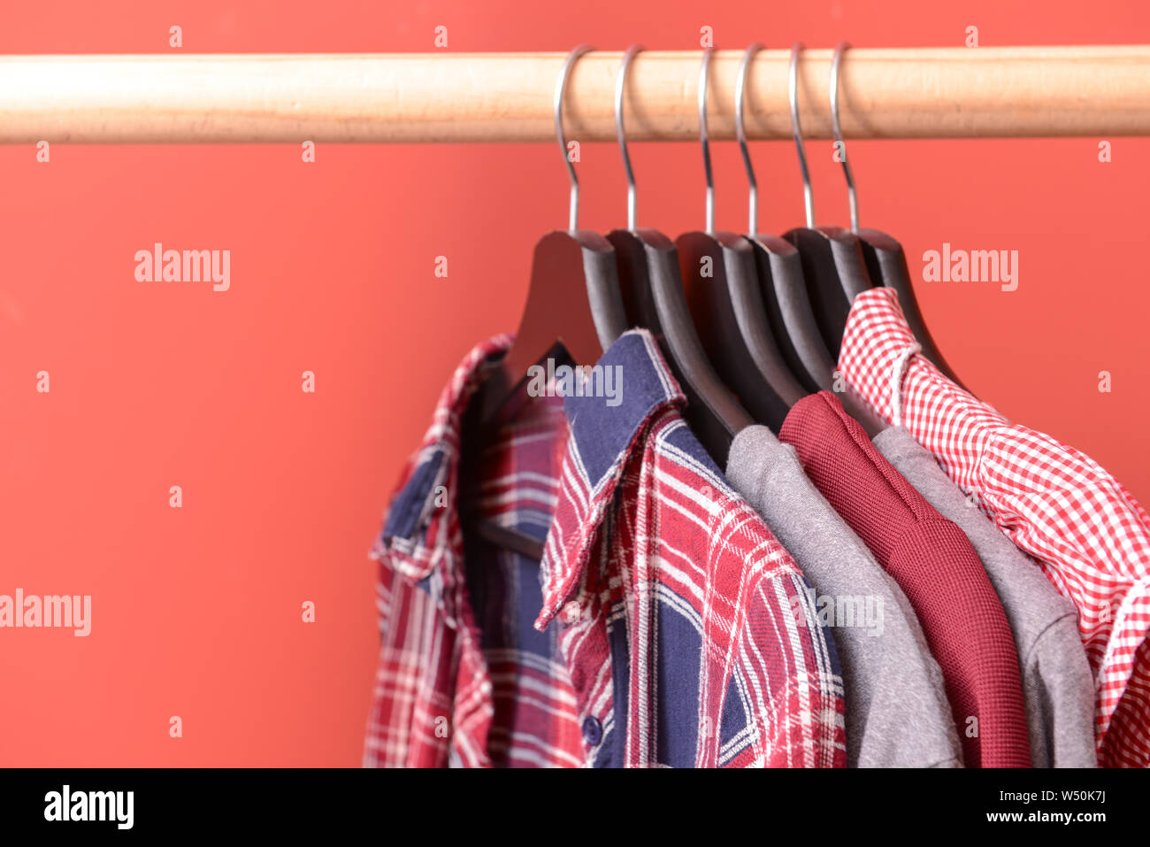 Rack with hanging clothes on color background Stock Photo - Alamy