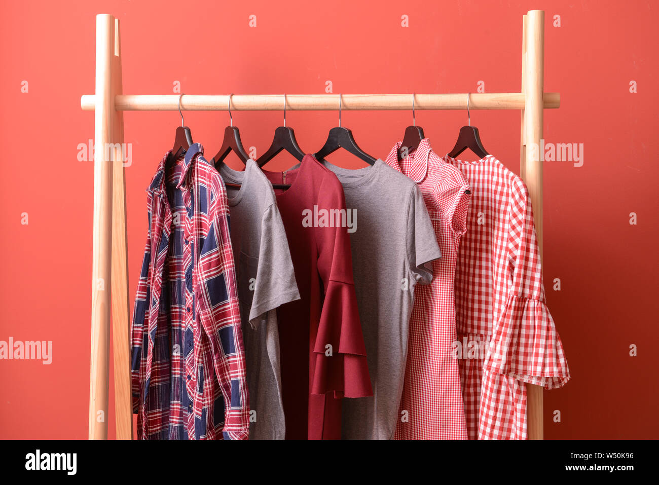 Rack with hanging clothes on color background Stock Photo - Alamy