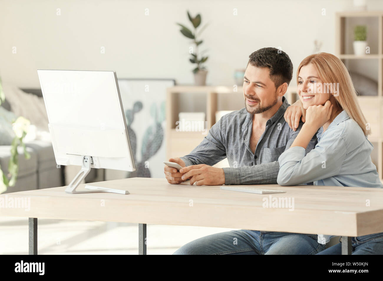 Happy couple in love using computer at home Stock Photo - Alamy