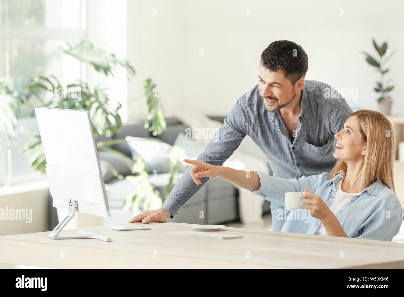 Happy couple in love using computer at home Stock Photo - Alamy