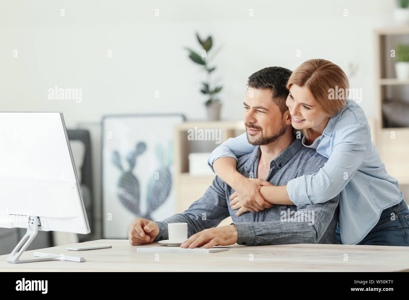 Happy couple in love using computer at home Stock Photo - Alamy