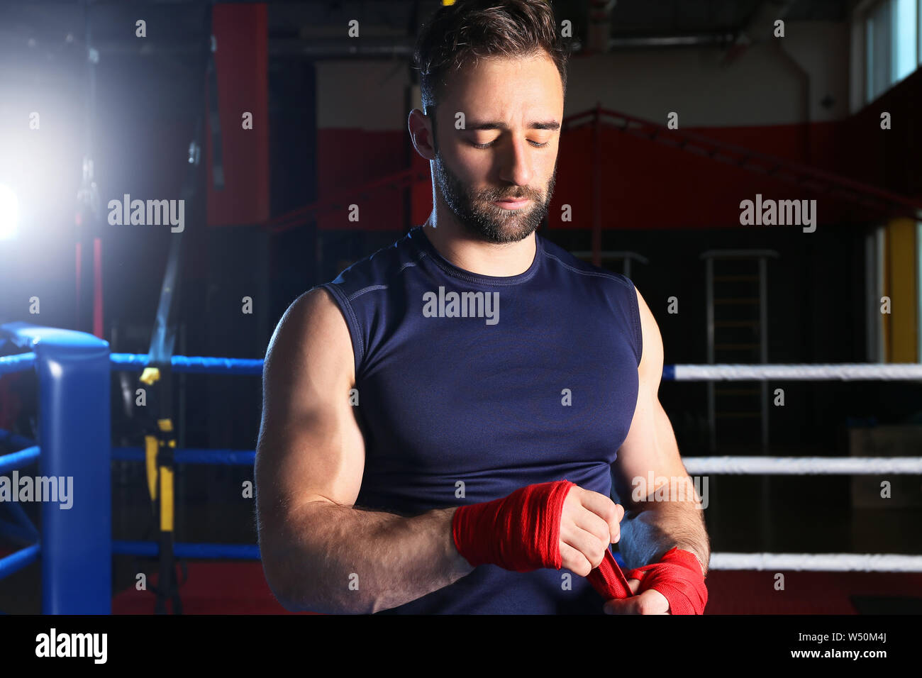 Sporty man applying wrist bands in boxing ring Stock Photo - Alamy