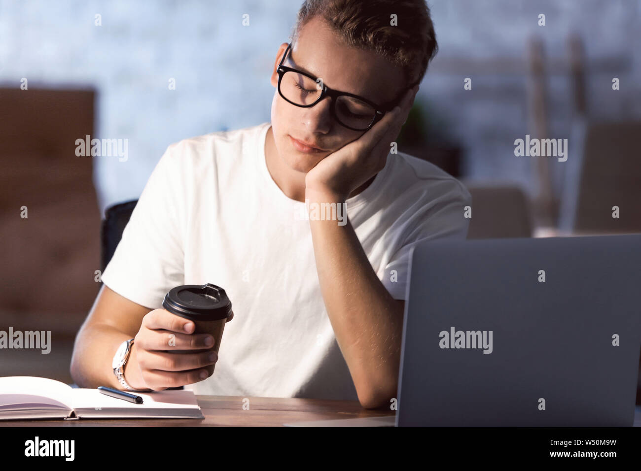 Tired male student preparing for exam in evening Stock Photo - Alamy
