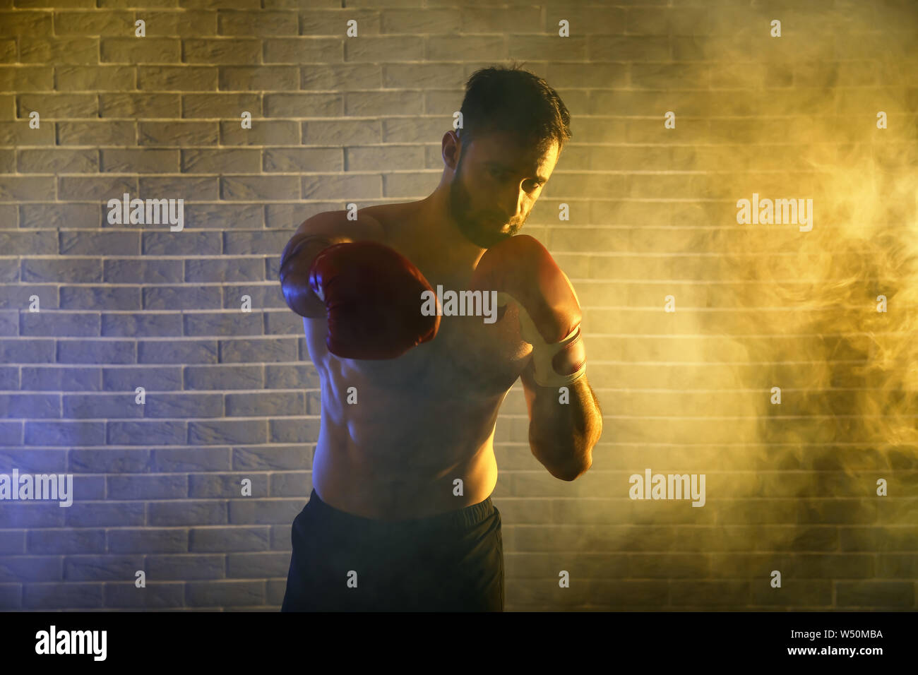 Strong male boxer against brick wall Stock Photo - Alamy