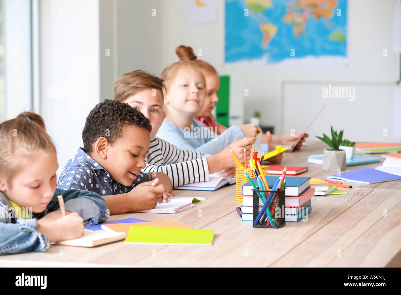 Cute little pupils during lesson in classroom Stock Photo - Alamy