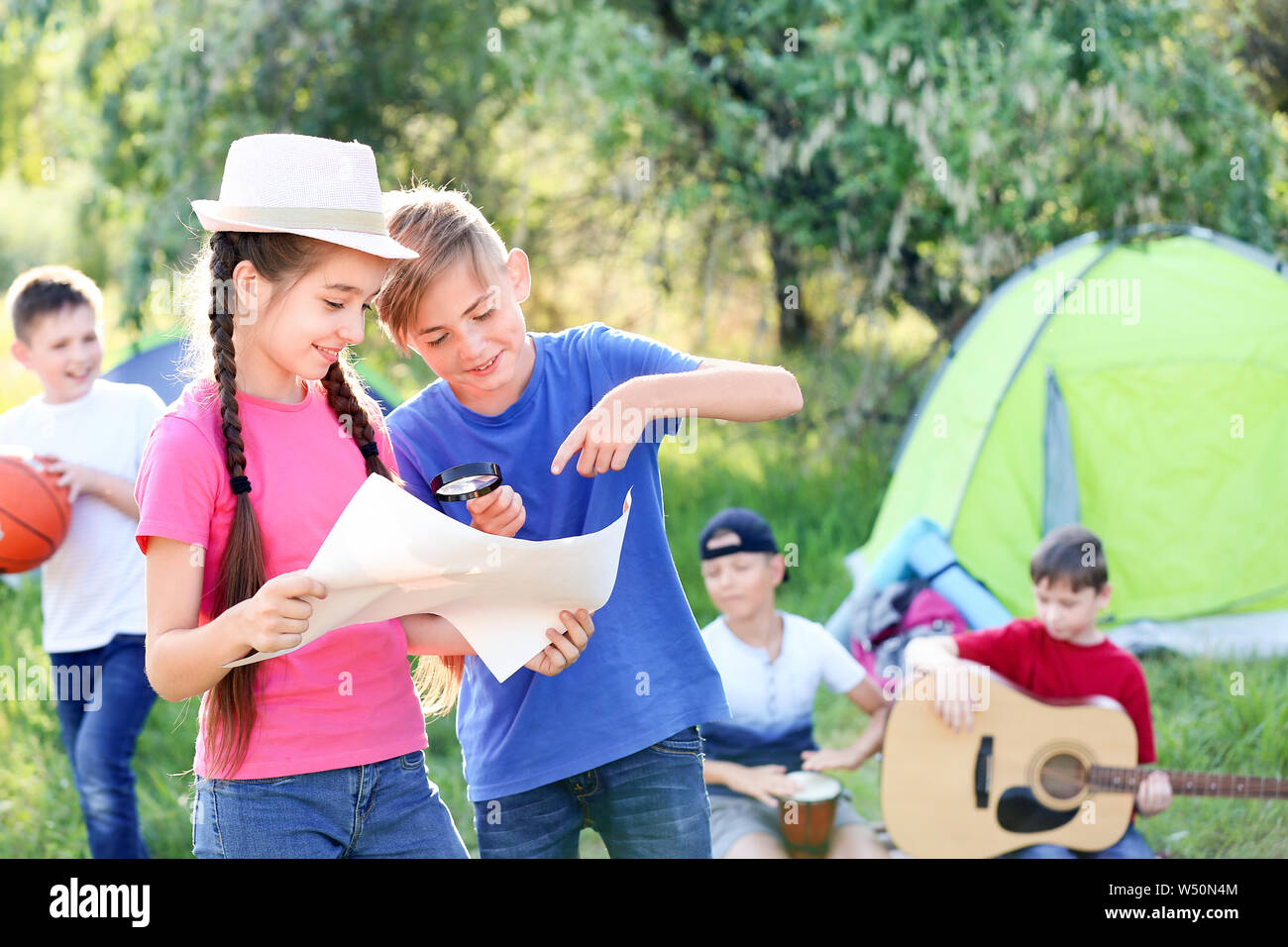 Little children with map resting at summer camp Stock Photo - Alamy