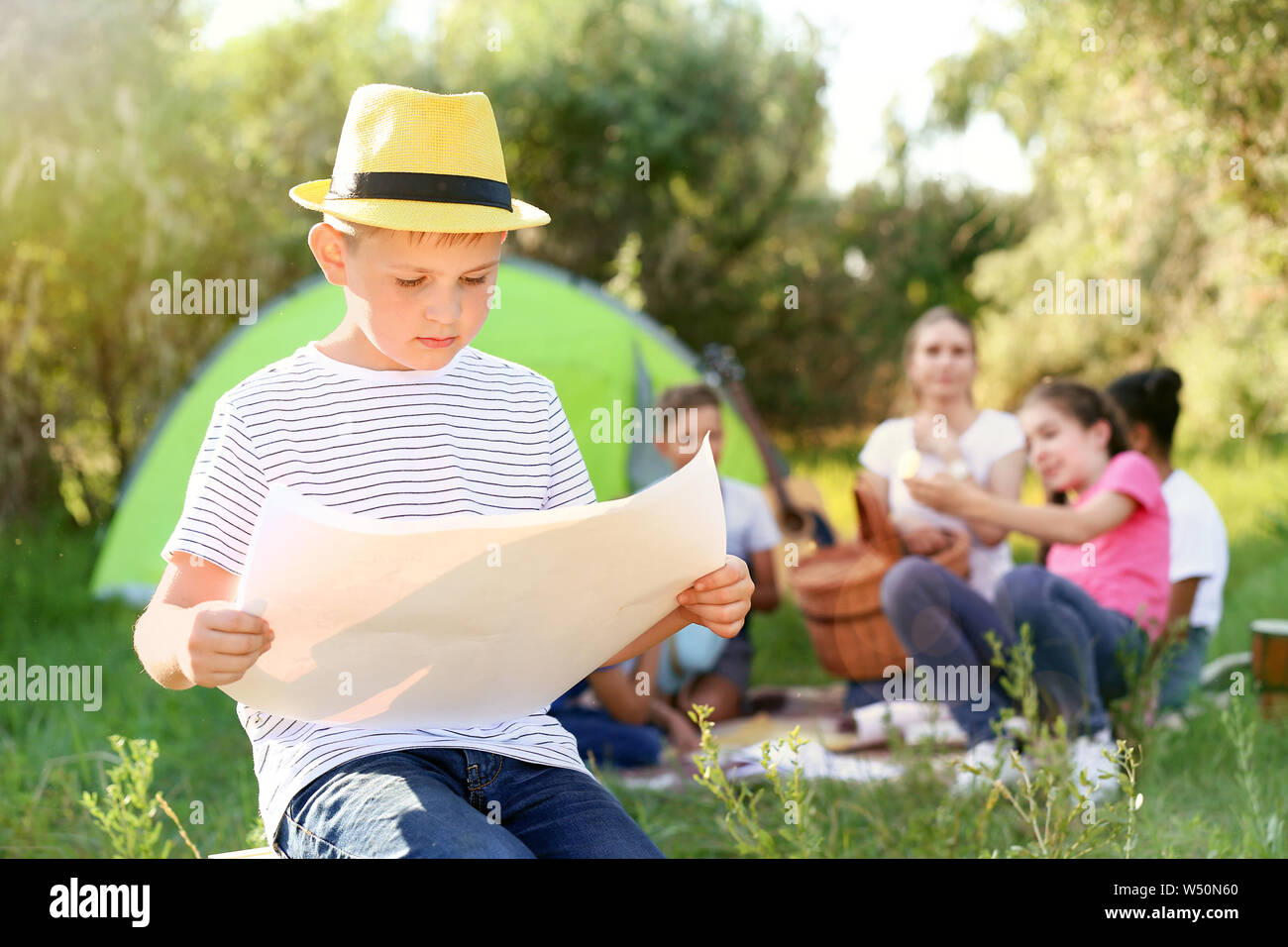 Little boy studying map at summer camp Stock Photo - Alamy