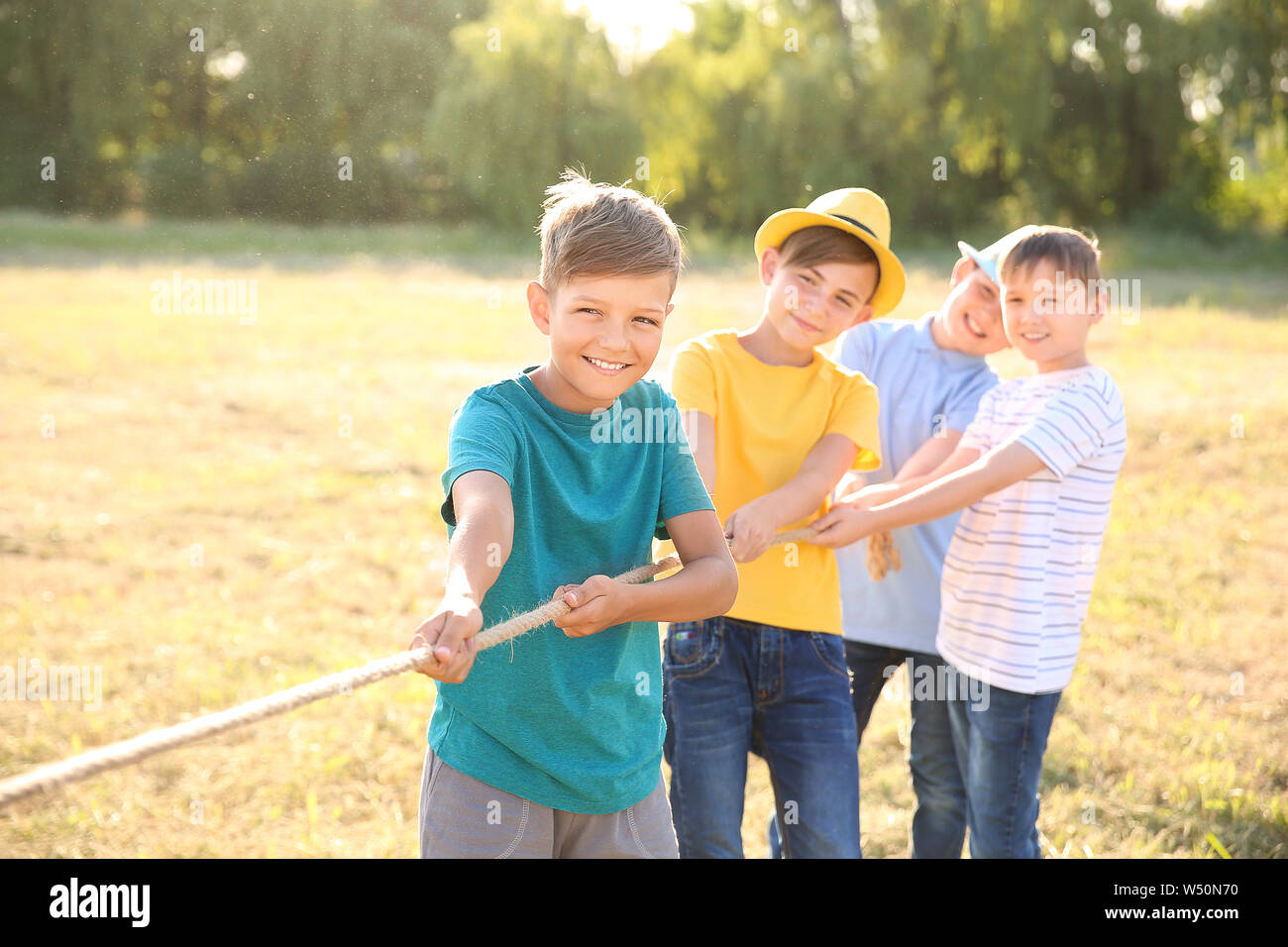 Group of children pulling rope at summer camp Stock Photo - Alamy