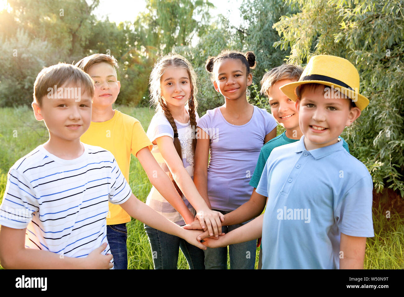 Group of children putting hands together outdoors Stock Photo - Alamy