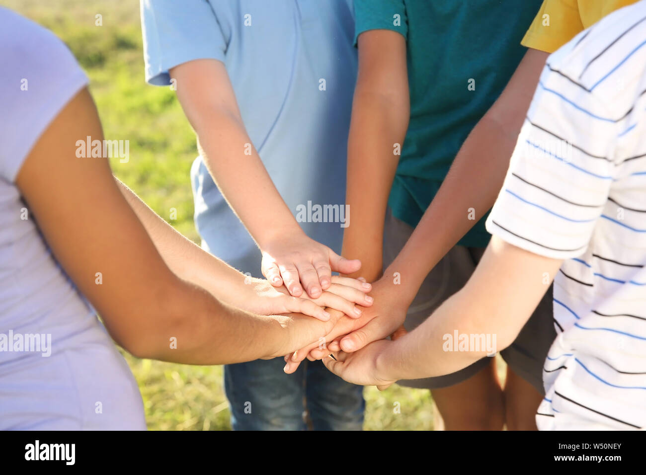 Children putting hands together outdoors Stock Photo - Alamy