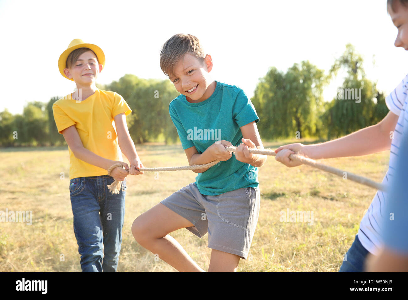 Group of children pulling rope at summer camp Stock Photo - Alamy