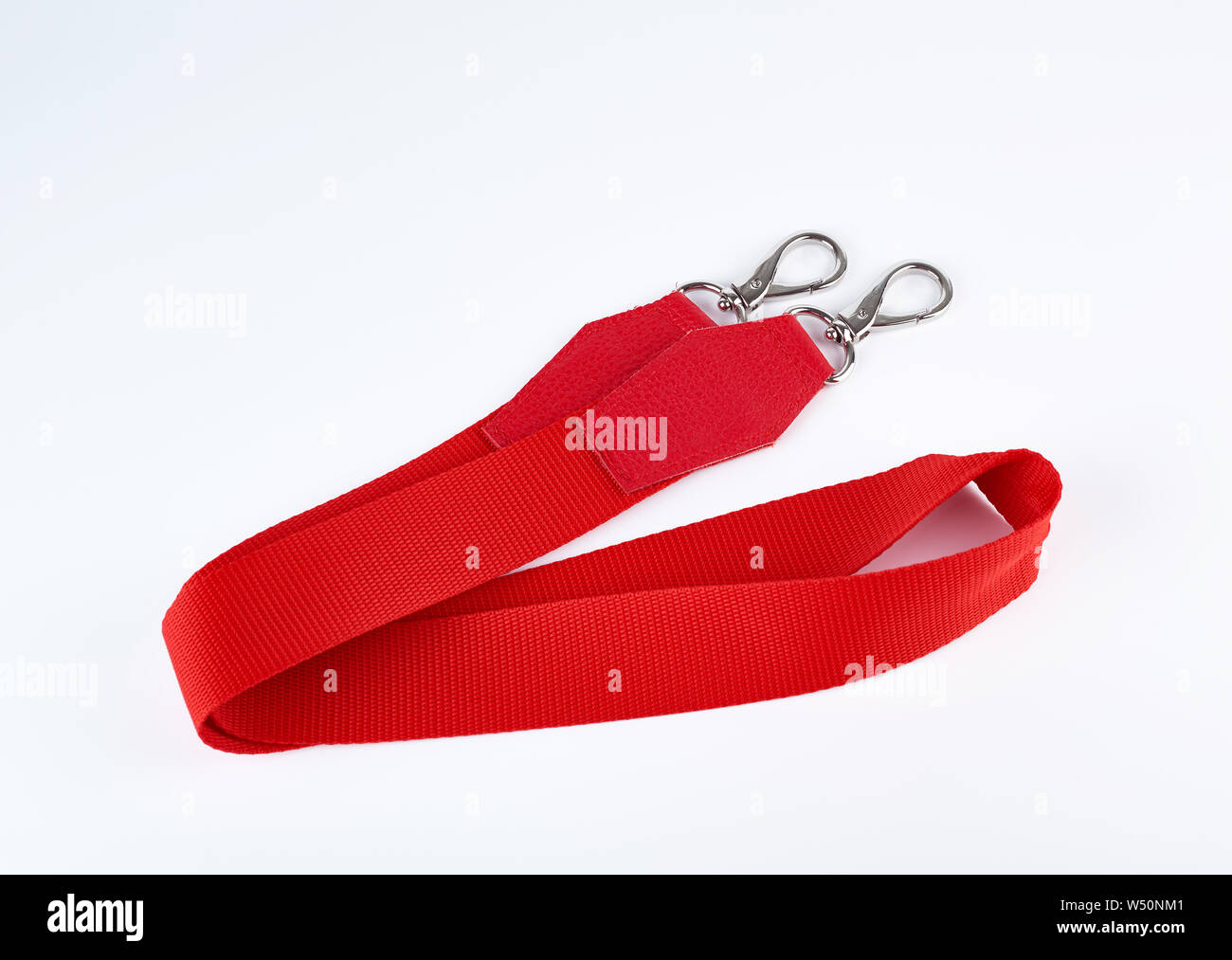 red textile handles with metal clasps for a bag on a white background ...