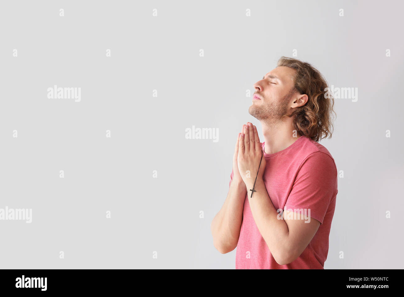 Religious young man praying on white background Stock Photo - Alamy