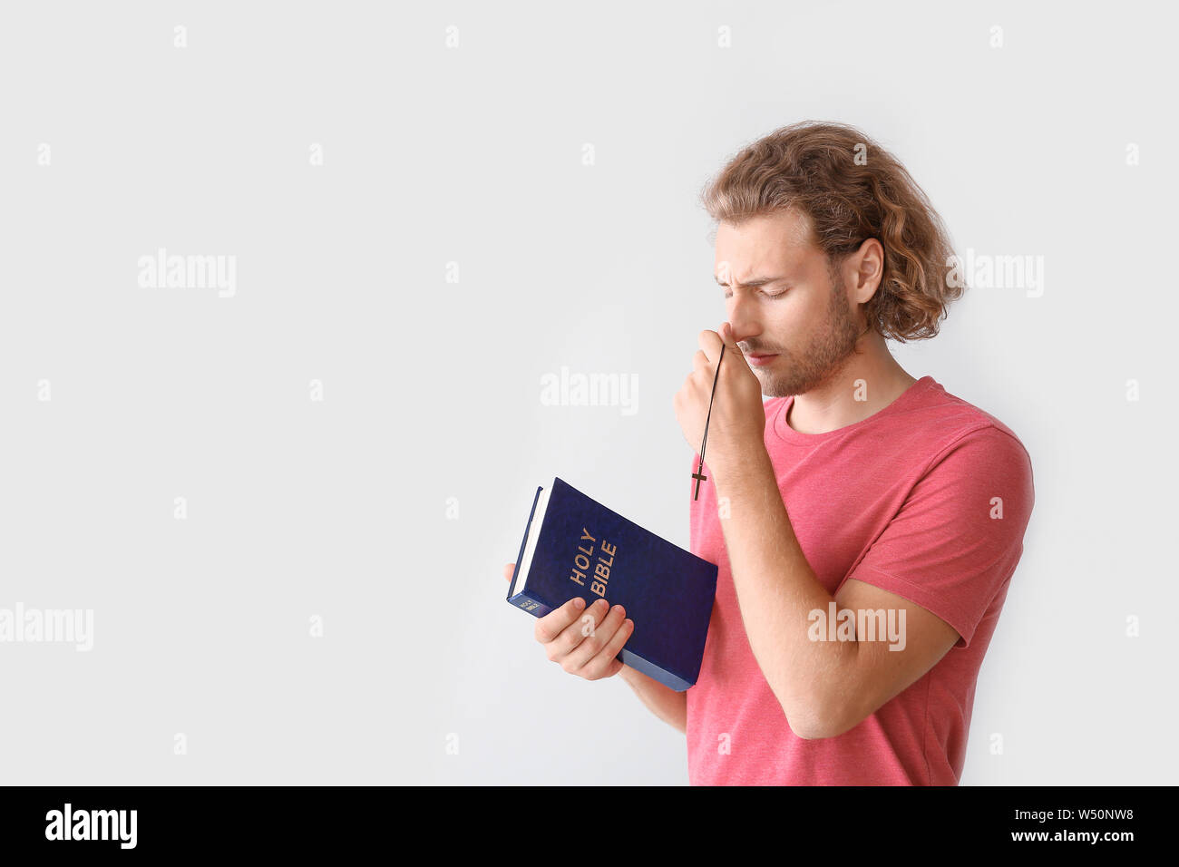 Religious young man praying on white background Stock Photo - Alamy