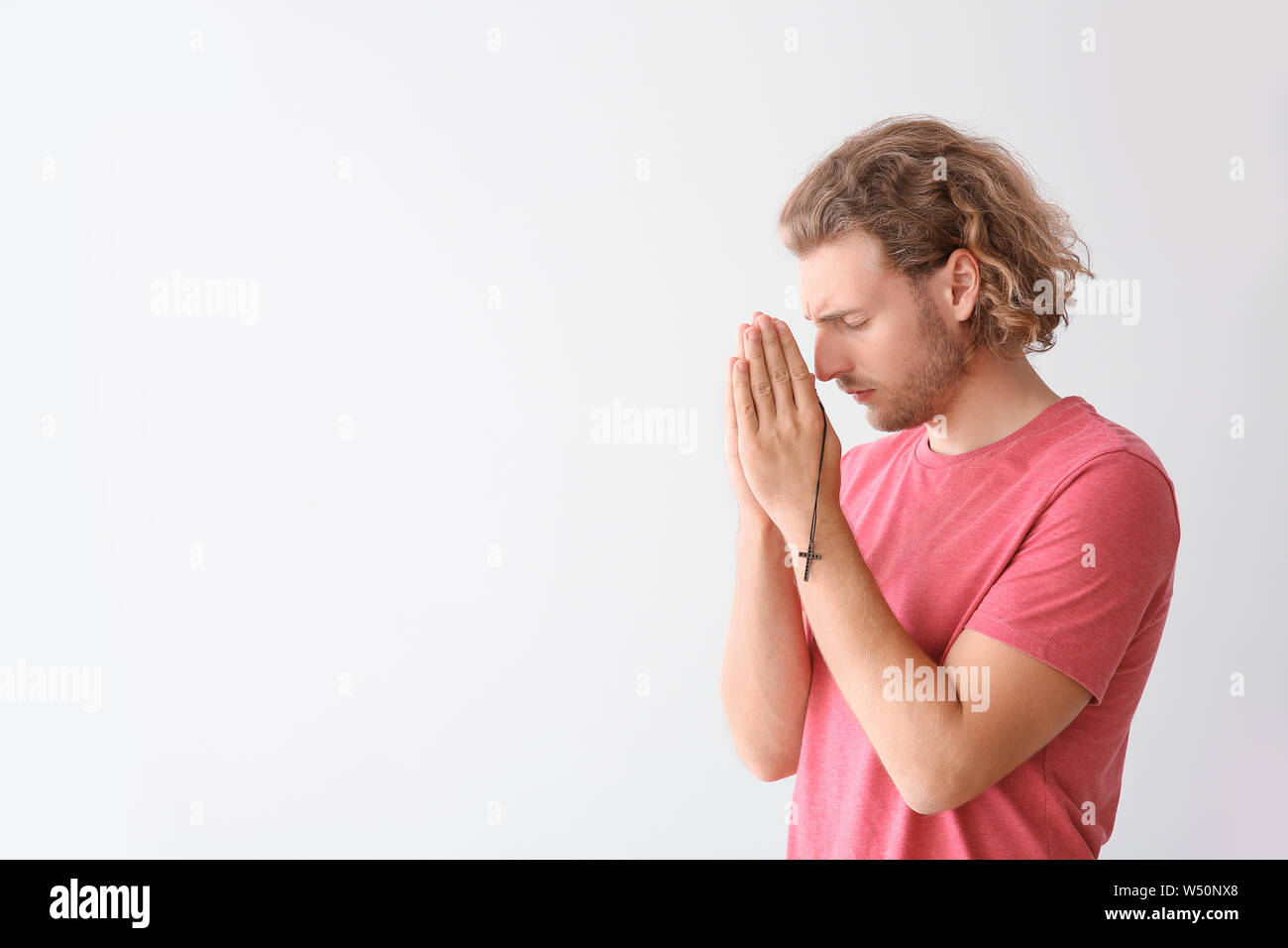 Religious young man praying on white background Stock Photo - Alamy