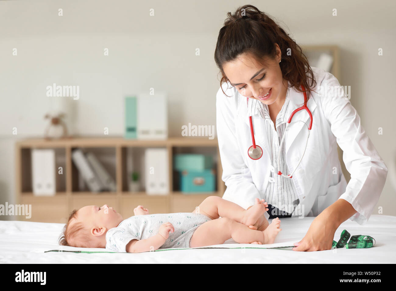 Pediatrician examining little baby in clinic Stock Photo - Alamy