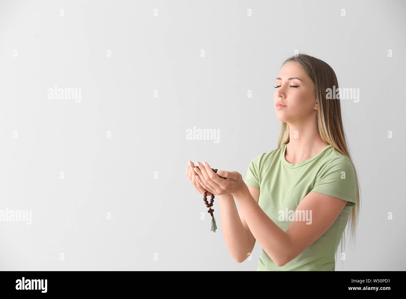 Religious young woman praying on white background Stock Photo - Alamy