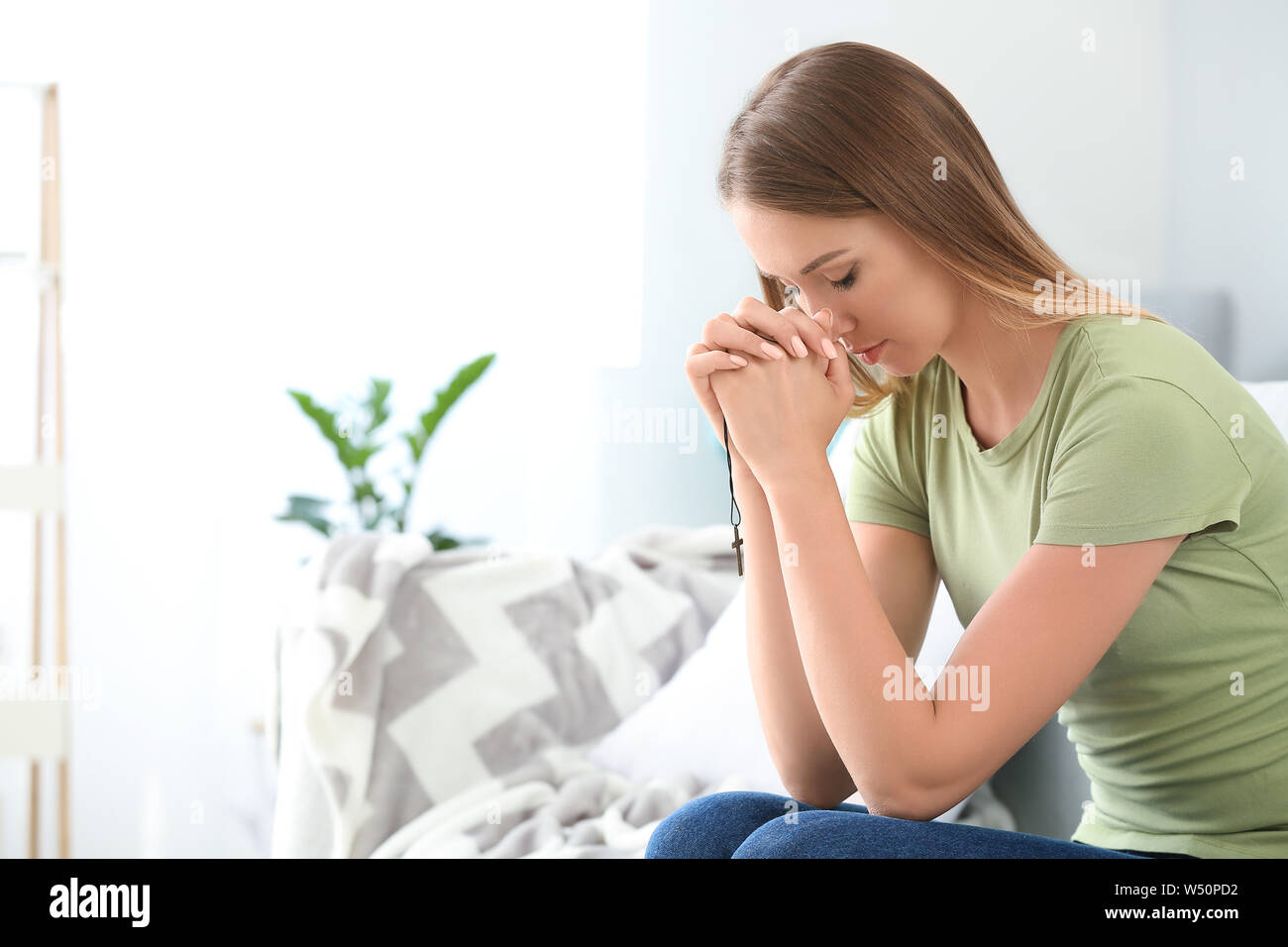 Religious young woman praying at home Stock Photo - Alamy