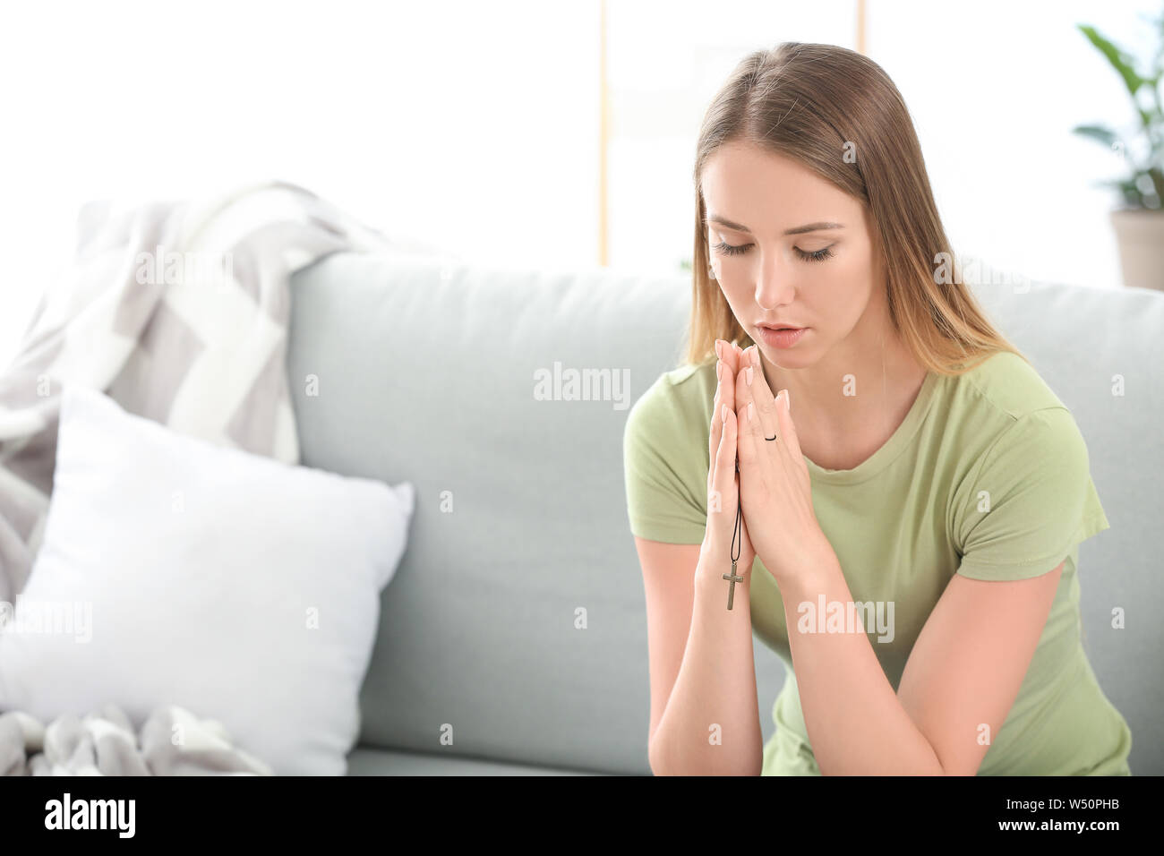 Religious young woman praying at home Stock Photo - Alamy