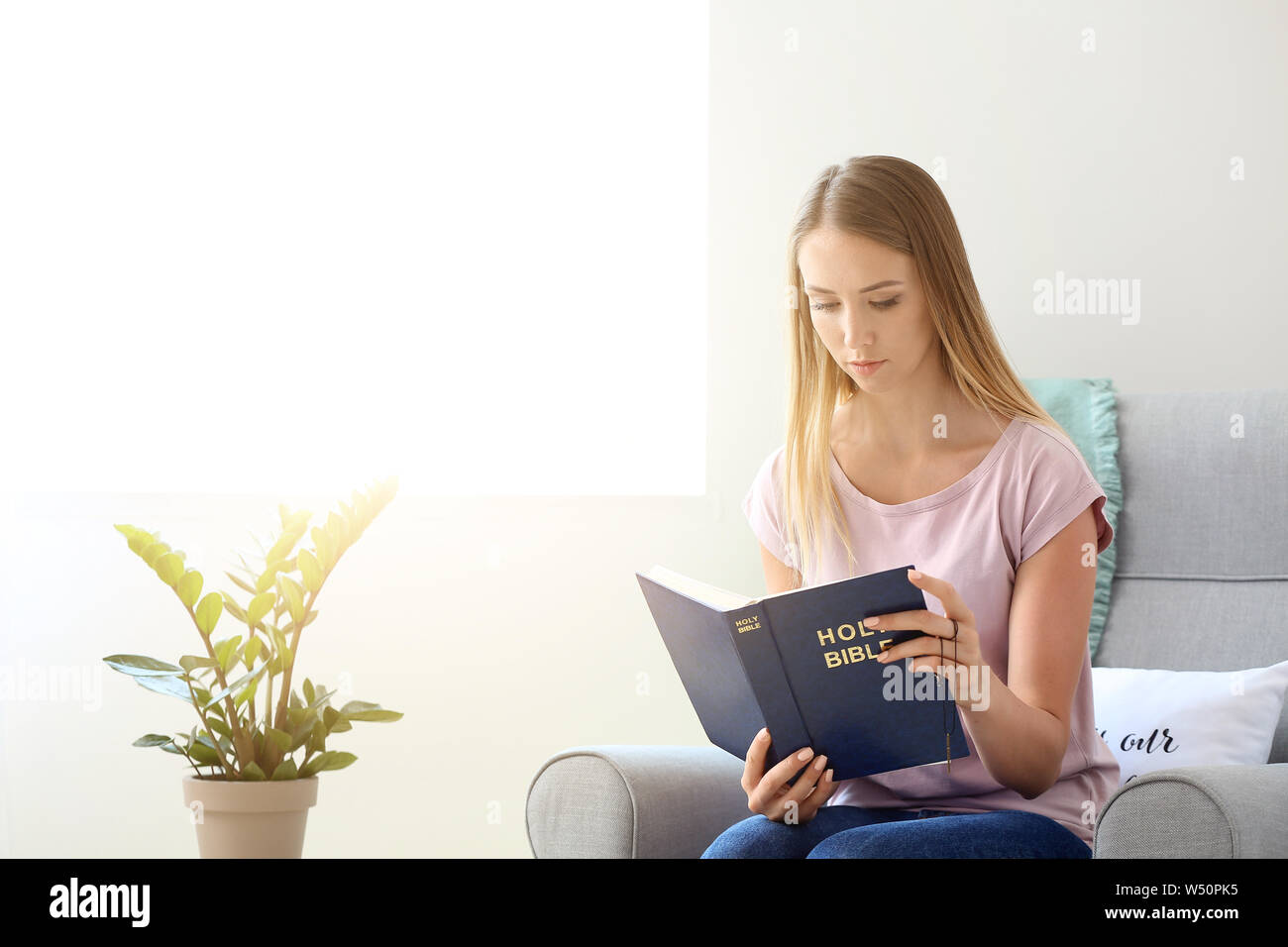 Religious young woman reading Bible at home Stock Photo - Alamy