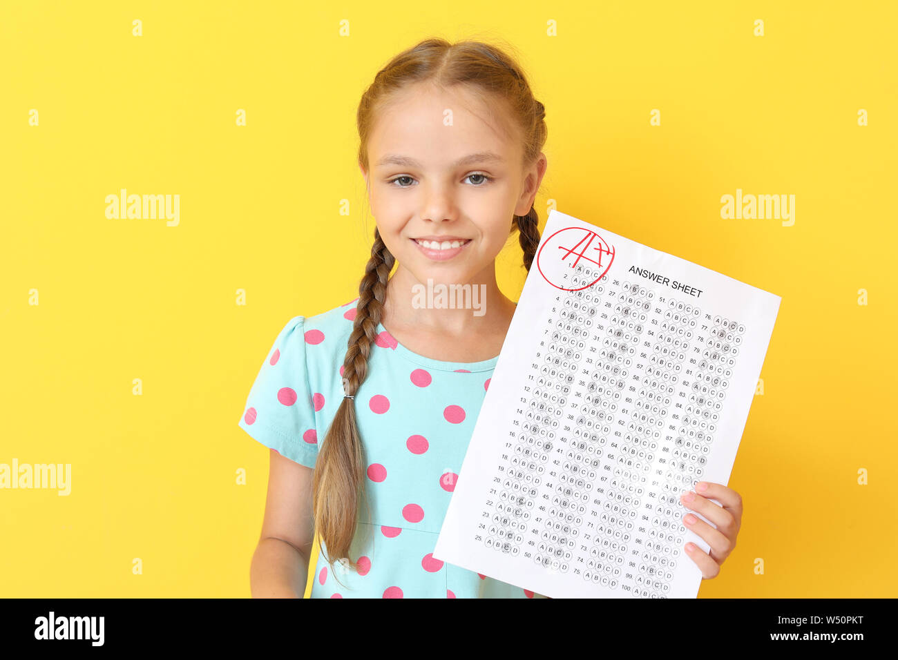 Happy girl with answer sheet for school test on color background Stock ...