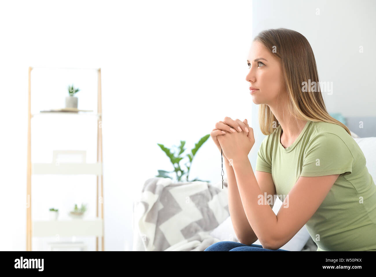 Religious young woman praying at home Stock Photo - Alamy