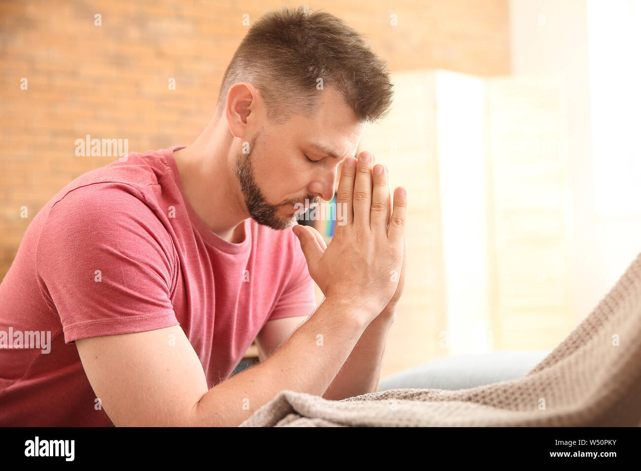 Religious man praying at home Stock Photo - Alamy