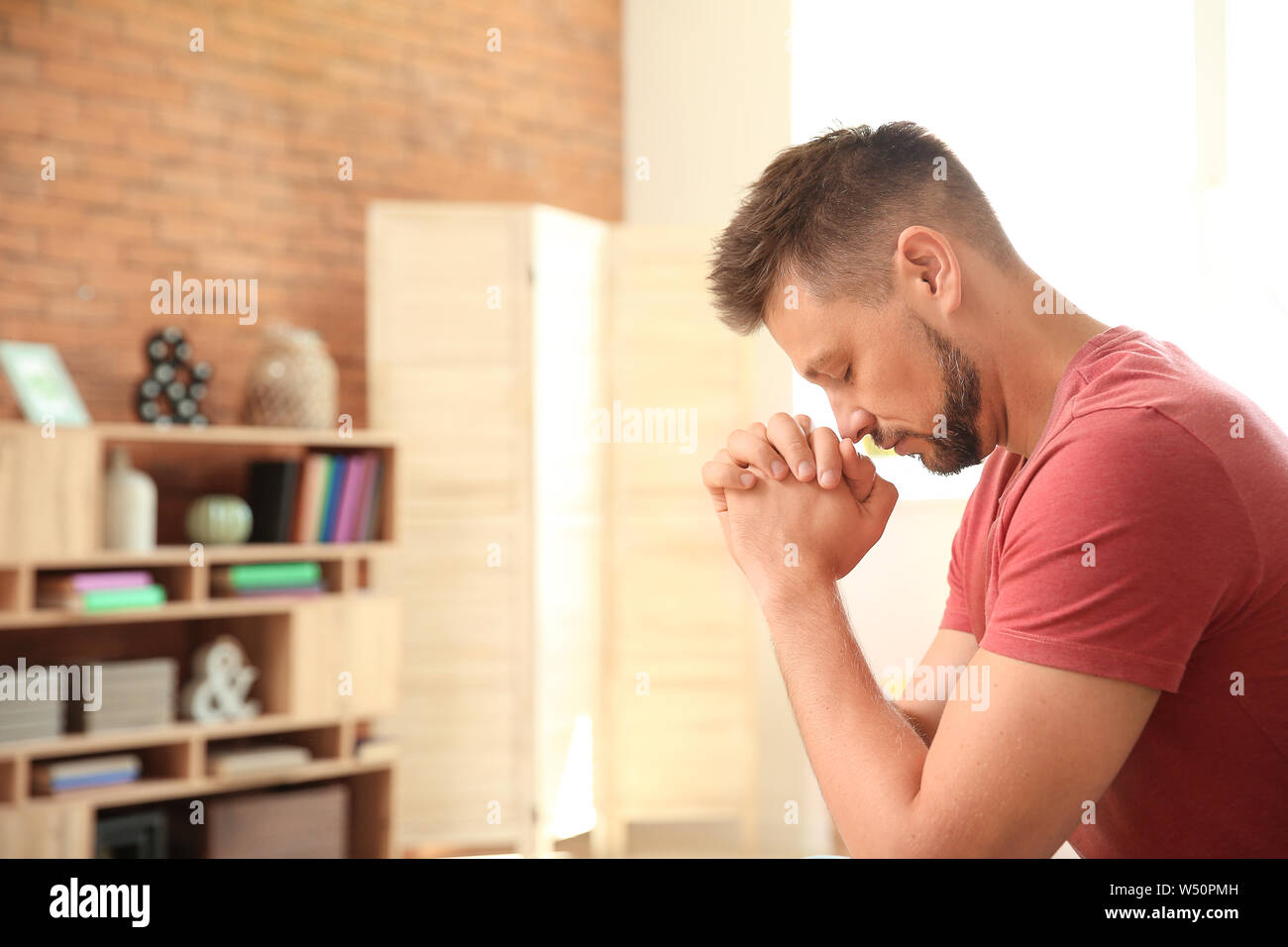 Religious man praying at home Stock Photo - Alamy