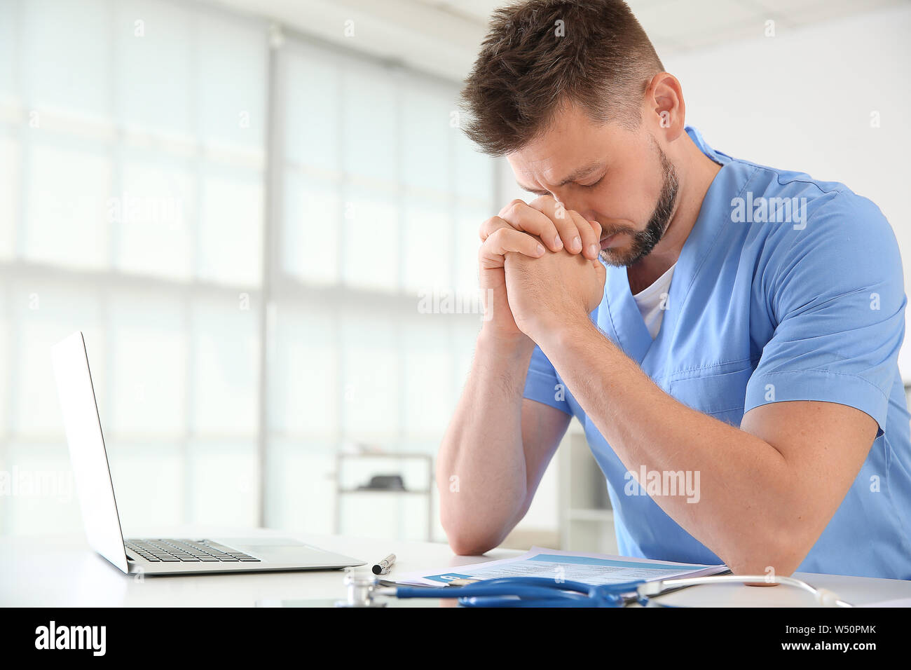 Religious doctor praying in clinic Stock Photo - Alamy