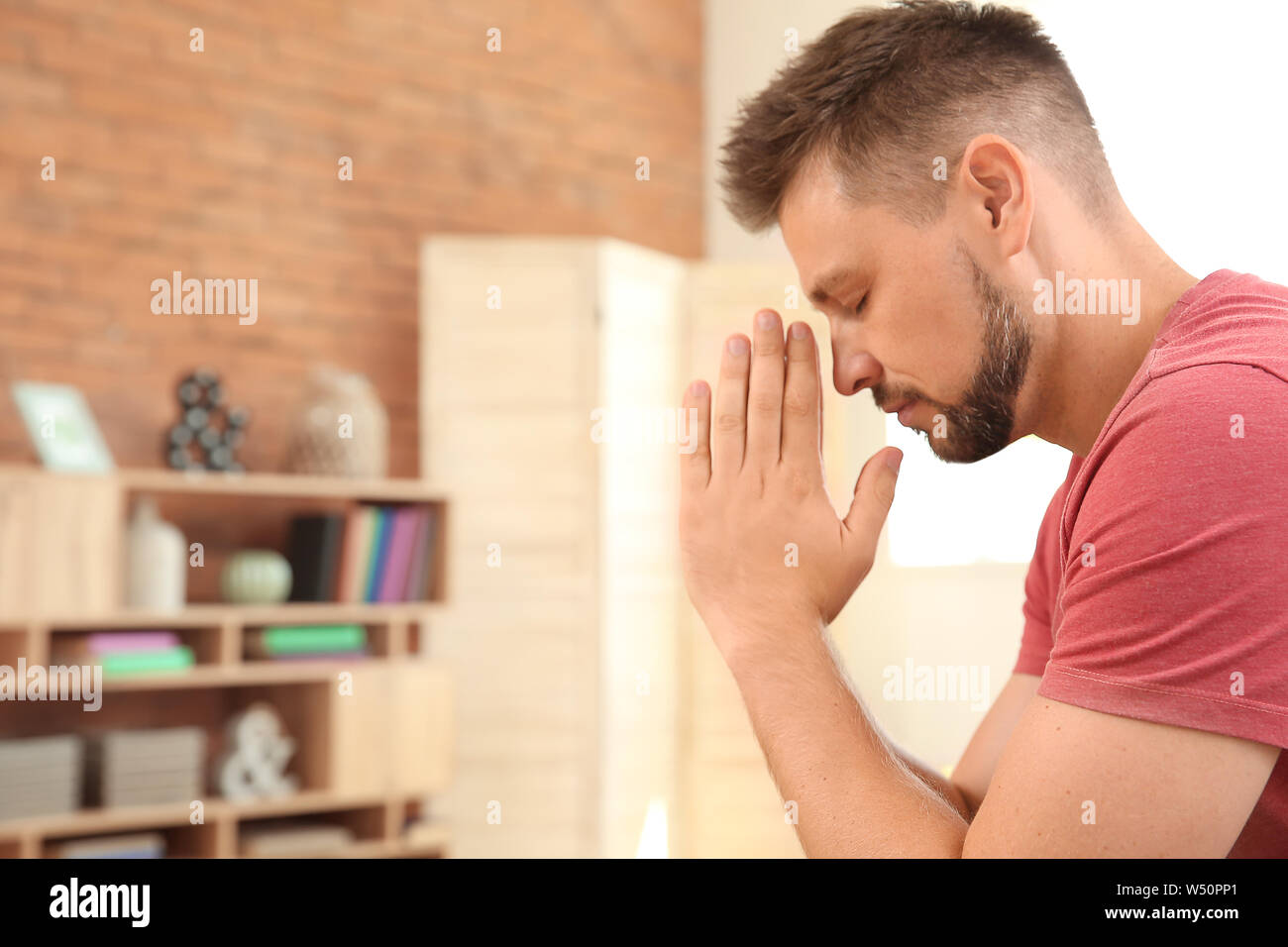Religious man praying at home Stock Photo - Alamy