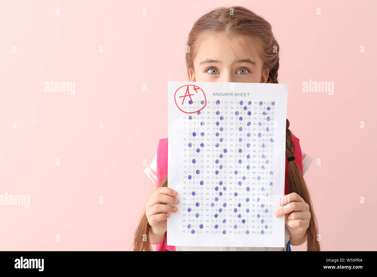 Happy girl with answer sheet for school test on color background Stock ...