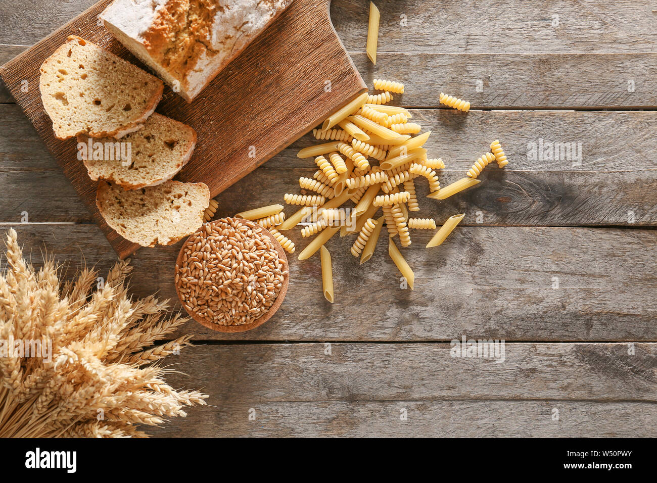 Fresh bread with pasta and wheat grains on wooden table Stock Photo - Alamy