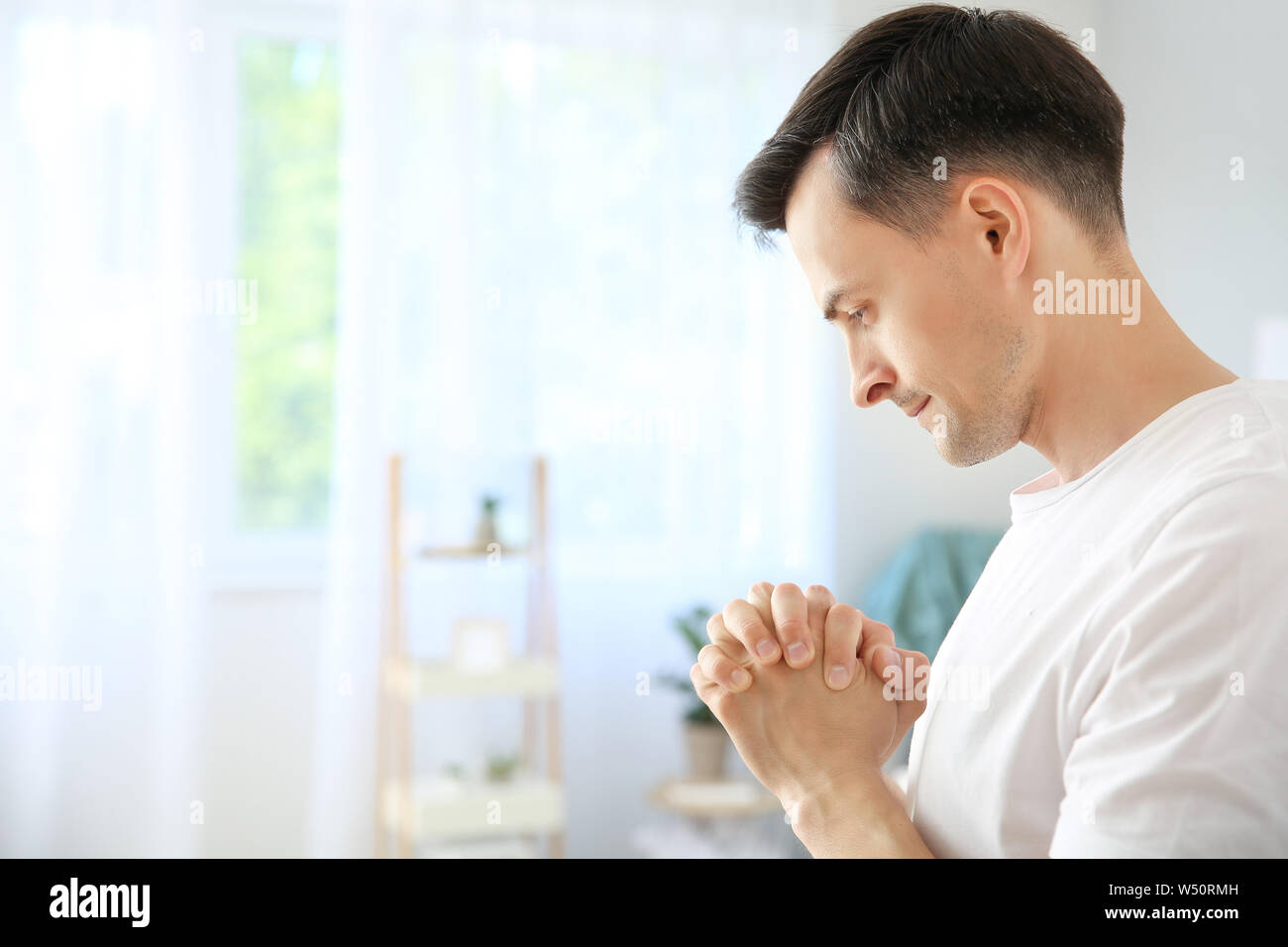 Religious man praying to God at home Stock Photo - Alamy
