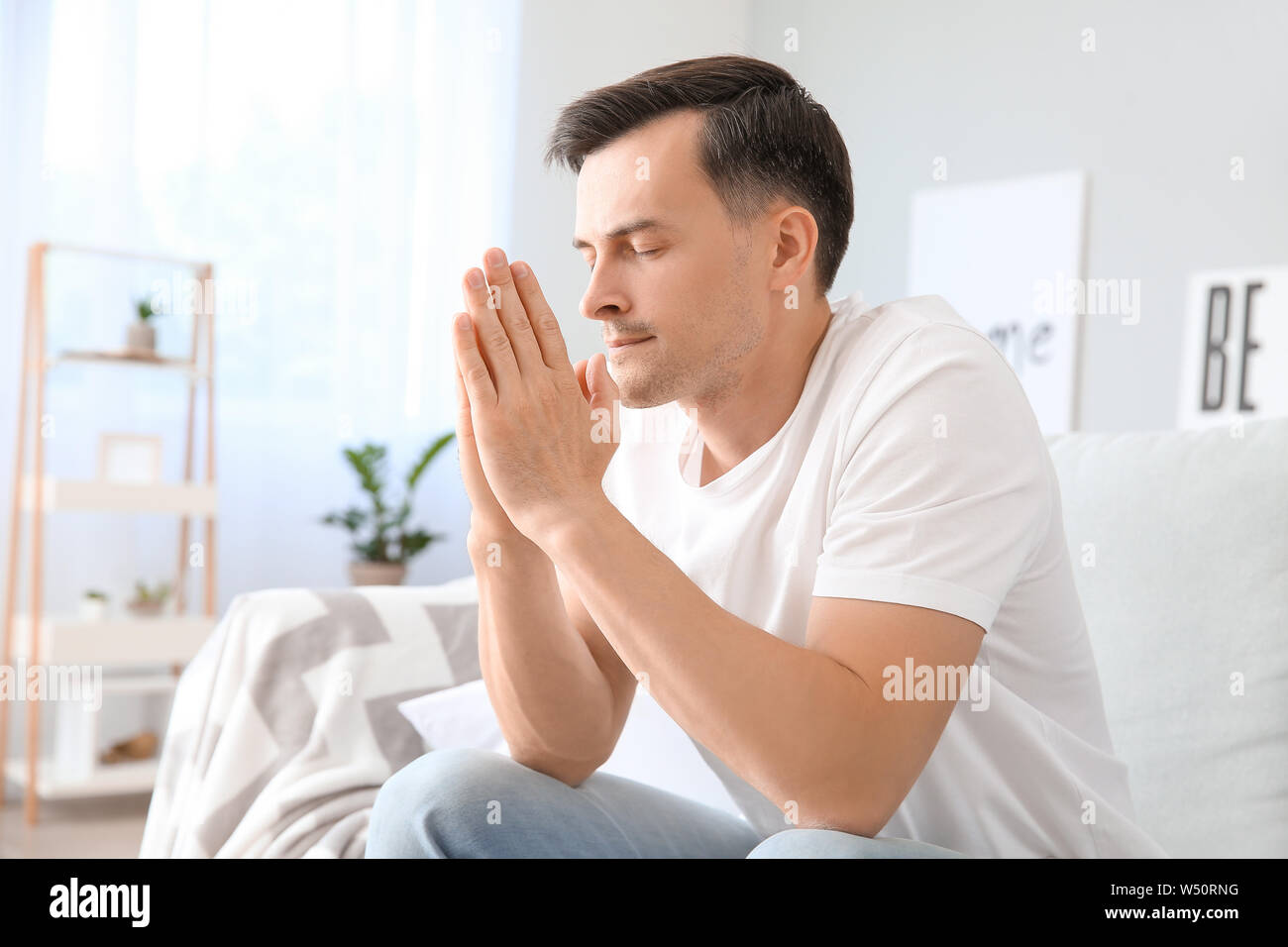 Religious man praying to God at home Stock Photo - Alamy