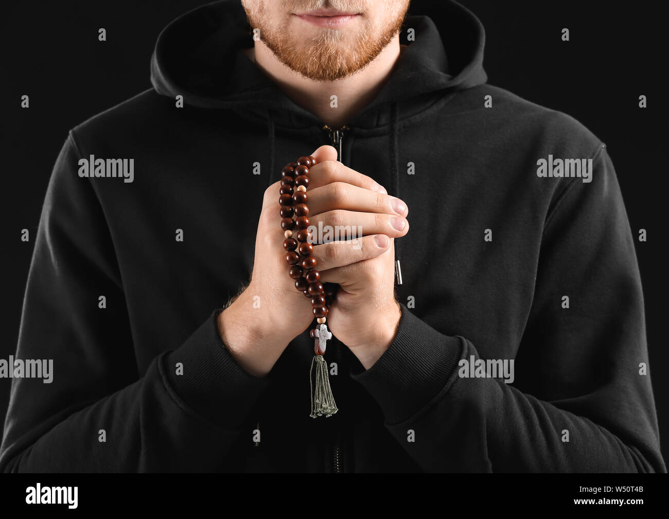 Religious young man praying to God on dark background, closeup Stock ...