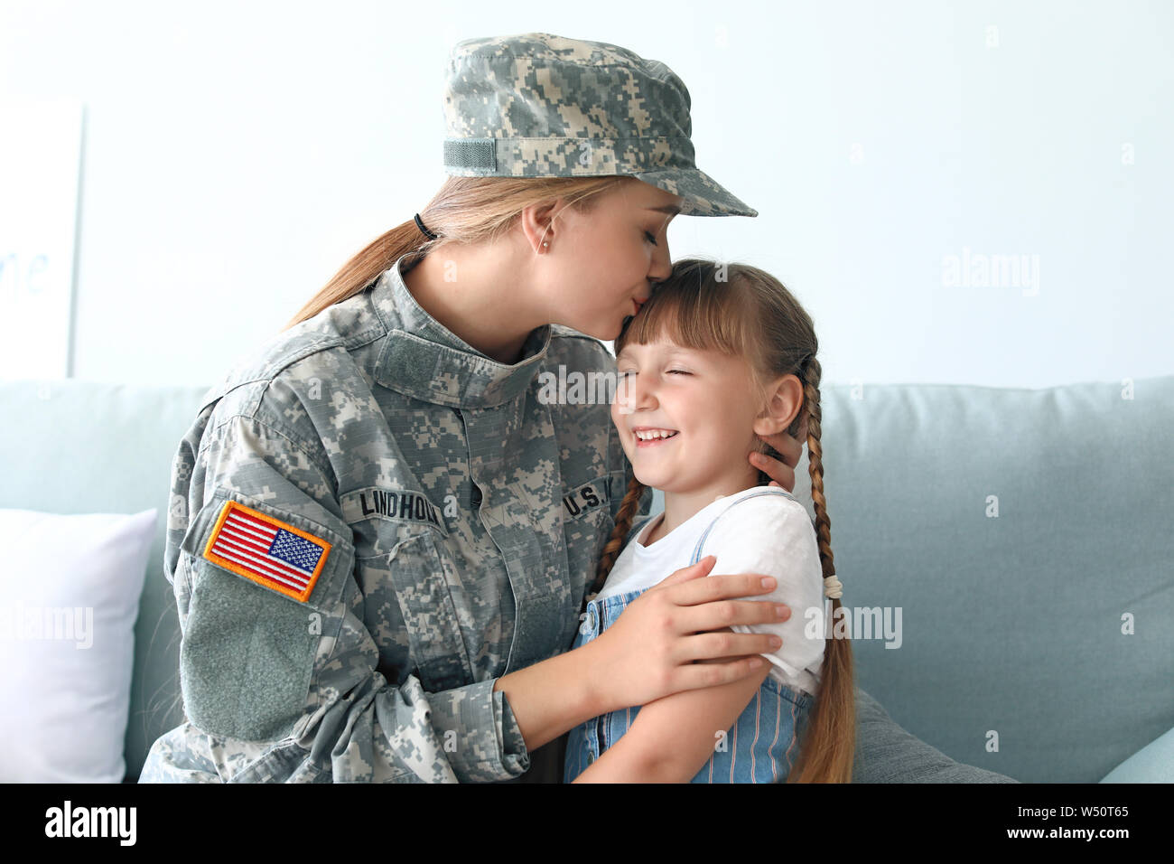Happy female soldier with her daughter at home Stock Photo - Alamy