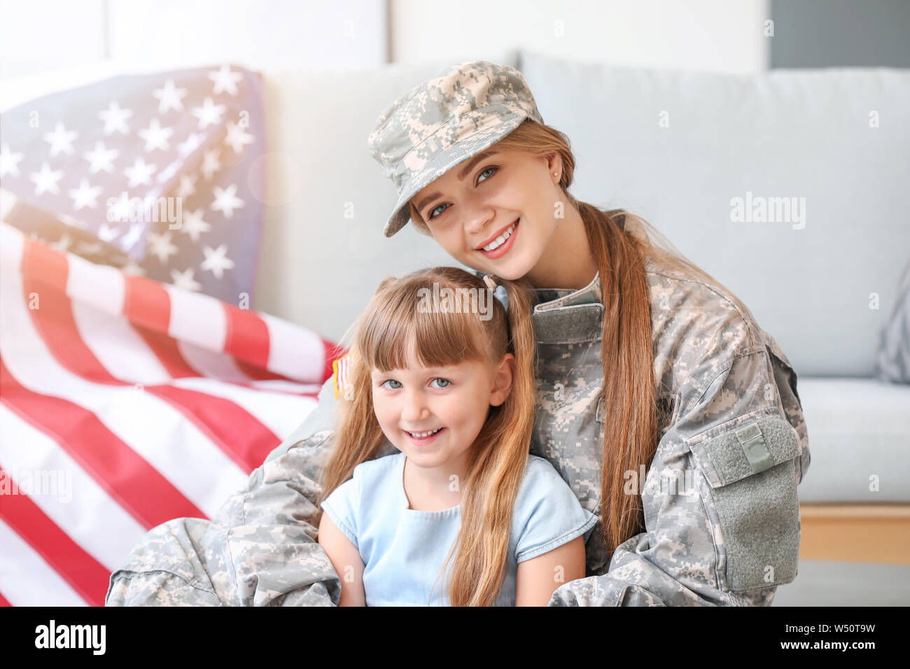 Happy female soldier with her daughter at home Stock Photo - Alamy