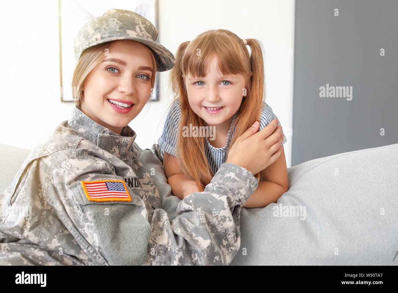 Happy female soldier with her daughter at home Stock Photo - Alamy