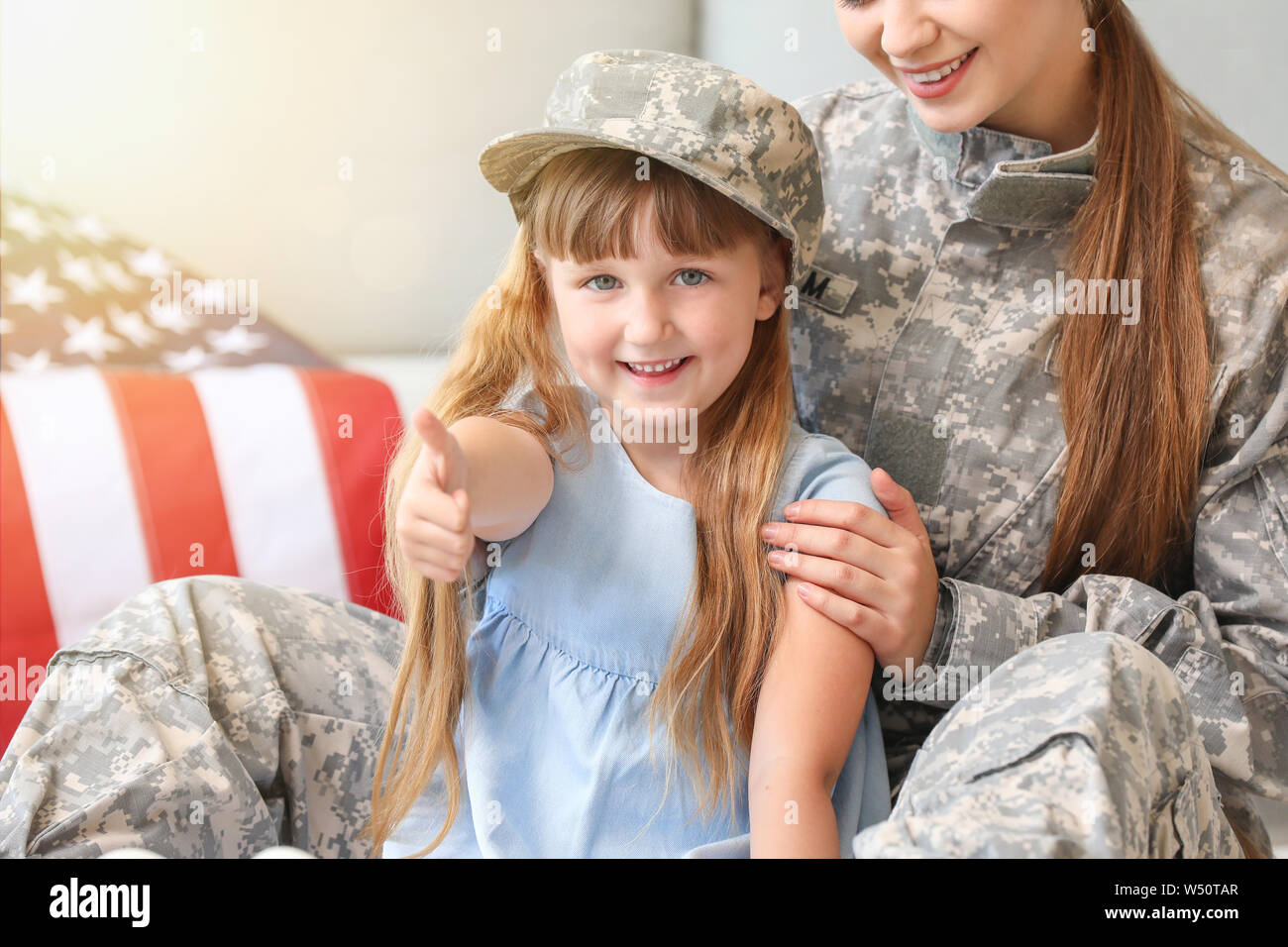 Happy female soldier with her daughter at home Stock Photo - Alamy