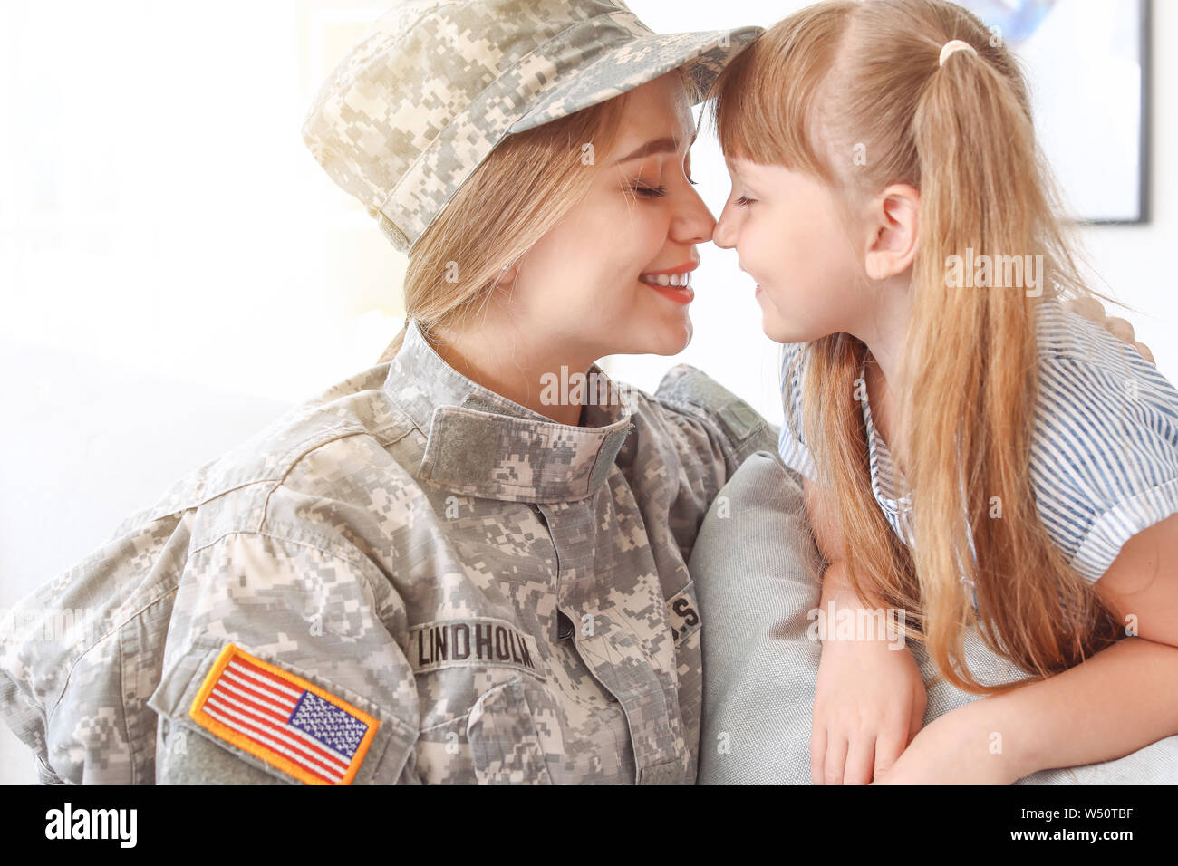 Happy female soldier with her daughter at home Stock Photo - Alamy