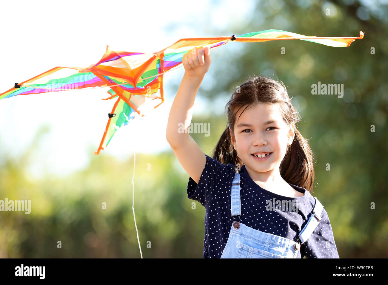 Little girl flying kite outdoors Stock Photo - Alamy