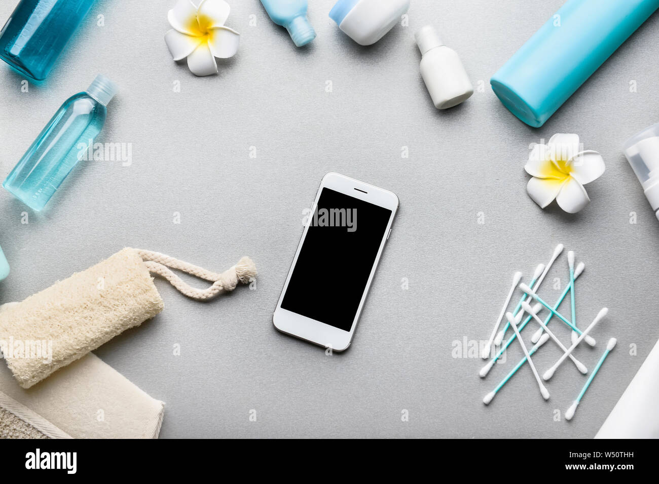 Mobile phone with cosmetics on grey background Stock Photo - Alamy