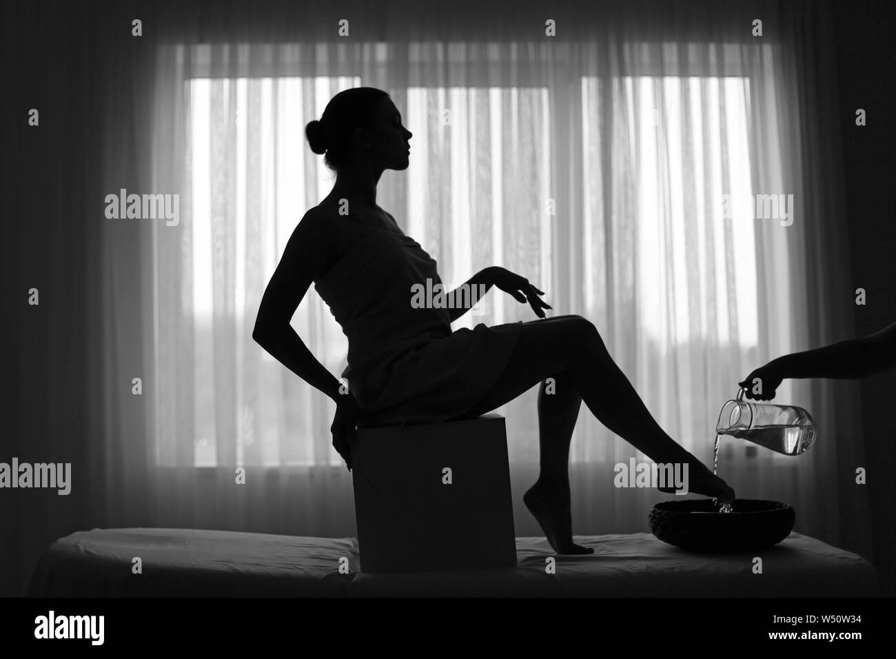 Spa therapist washing legs of young woman in beauty salon Stock Photo ...