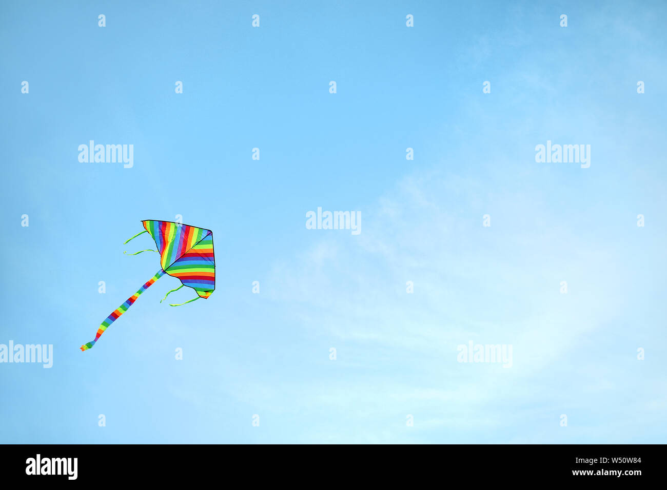 Colorful kite flying in blue sky Stock Photo - Alamy