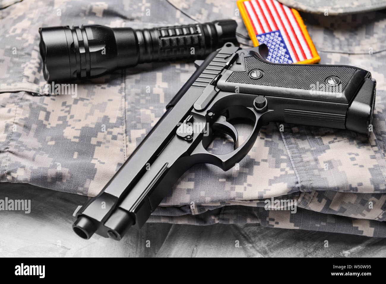 Military uniform, flashlight and gun on grey background, closeup Stock ...