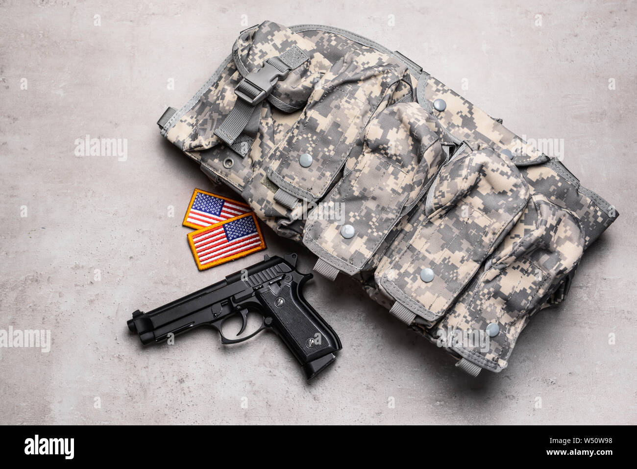Military uniform and gun on grey background Stock Photo - Alamy
