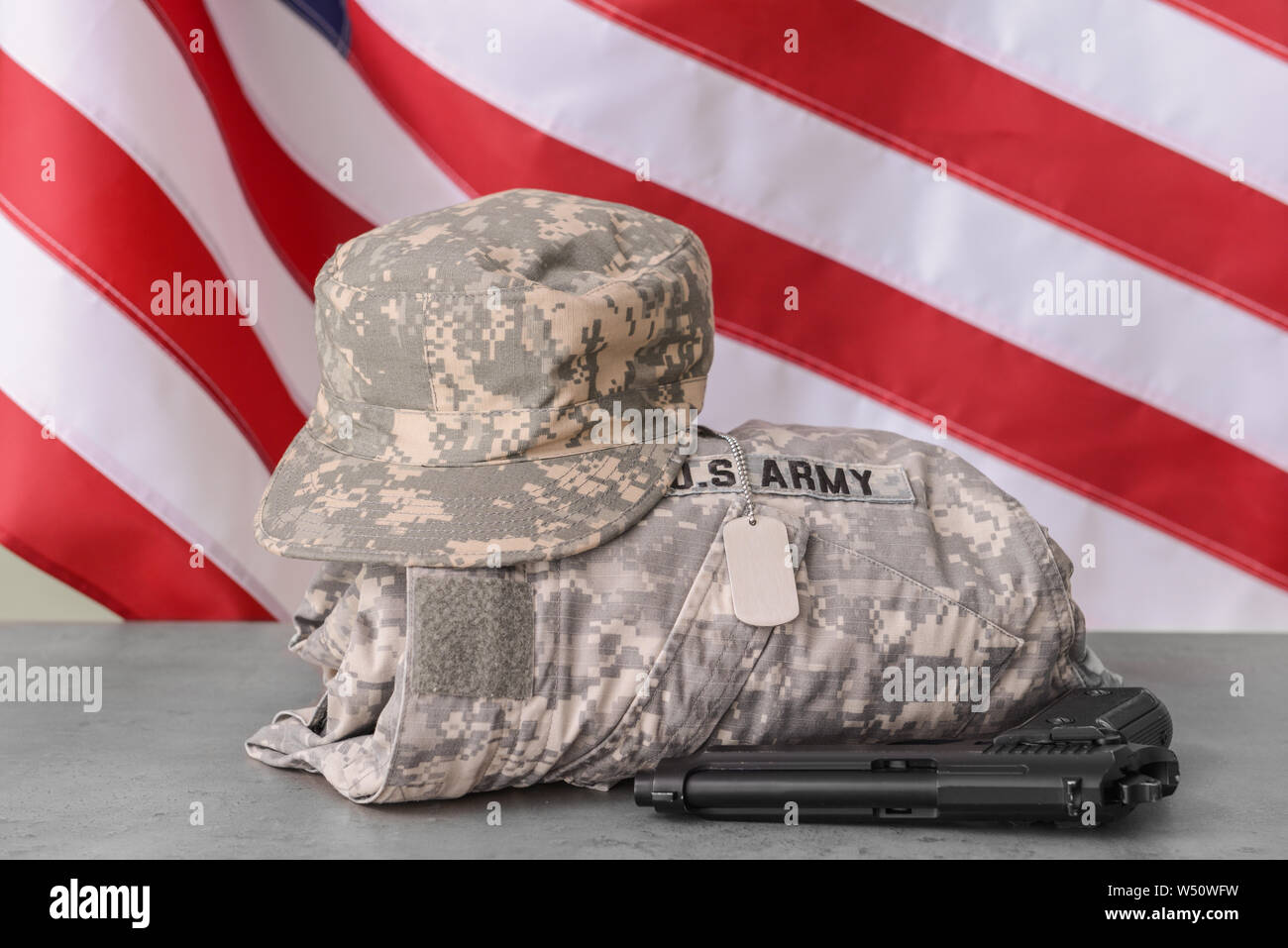 Military uniform and gun on table against USA flag Stock Photo - Alamy