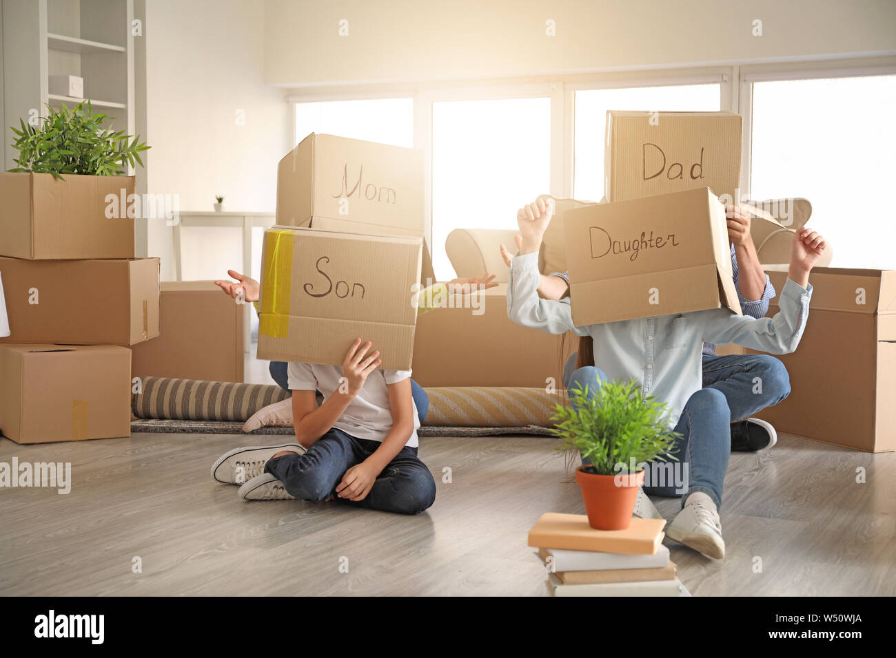Happy family with moving boxes having fun in their new house Stock ...