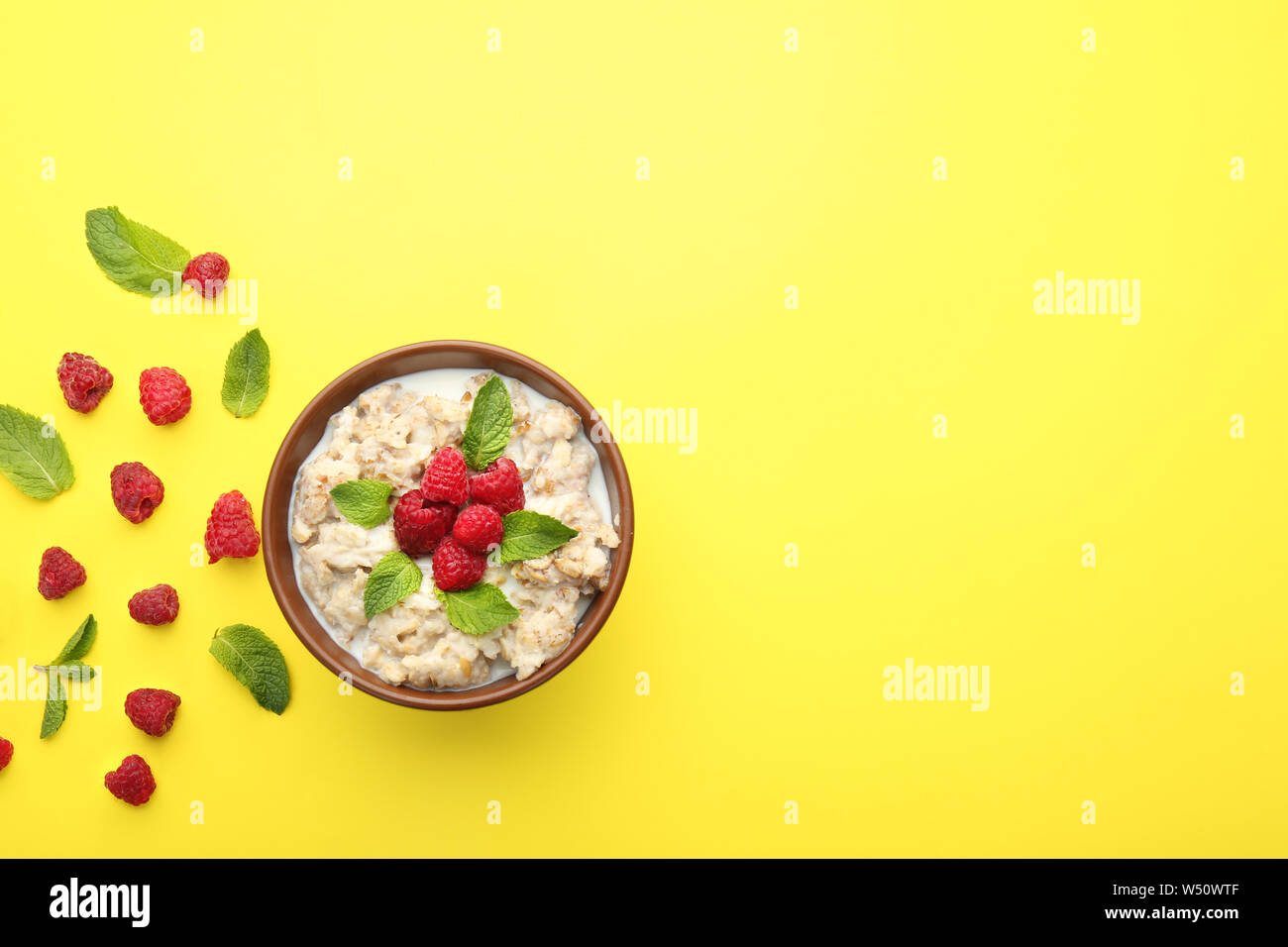 Bowl with tasty sweet oatmeal and raspberry on color background Stock ...