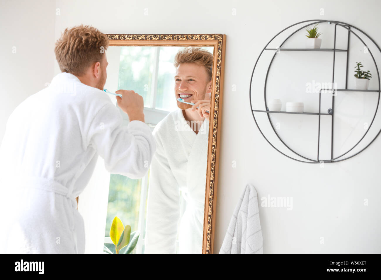 Morning of young man brushing teeth in bathroom Stock Photo - Alamy